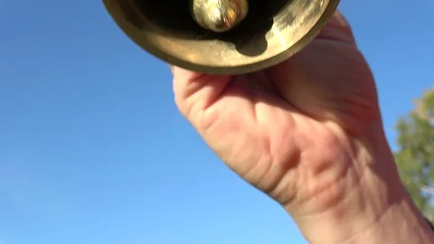 Man hand ringing brass bell on sky backg... | Stock Video | Pond5