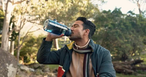 Man, hiking and drinking water from bott... | Stock Video | Pond5