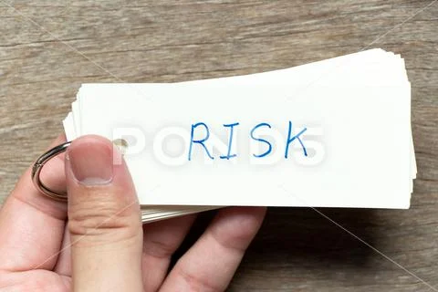 Man hold the flash card with handwriting word risk on wood background ...