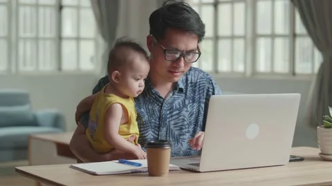 Man Holding Child And Working On Laptop ... | Stock Video | Pond5