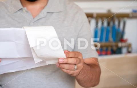 Man holding repair bill with pipes in his background ~ Premium Photo ...