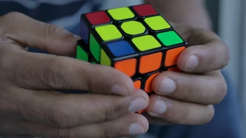 Man holding Rubik's cube and playing wit... | Stock Video | Pond5