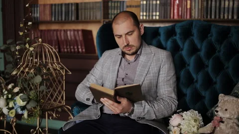 A man in a jacket sitting on the couch i... | Stock Video | Pond5