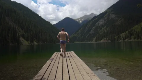 Man jumping into lake | Stock Video | Pond5