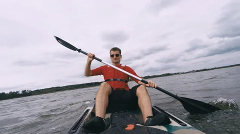 Man kayaking on open water, guy swims in... | Stock Video | Pond5