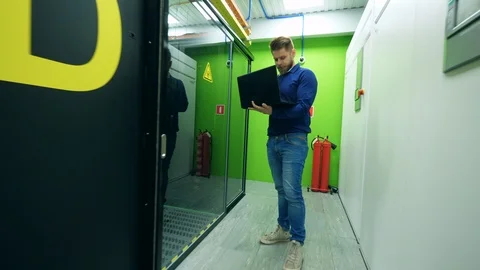 A man with a laptop is observing a room ... | Stock Video | Pond5