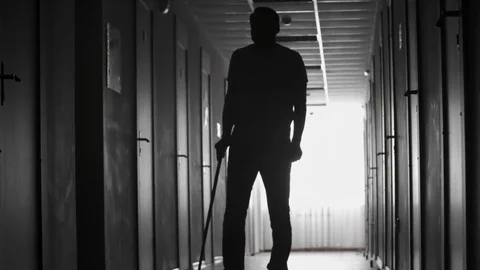 Man with Limp Walking along Corridor | Stock Video | Pond5