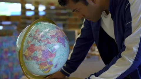 Man looking at world globe in library 4k | Stock Video | Pond5