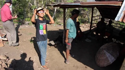 A man looks at the sun through eclipse w... | Stock Video | Pond5