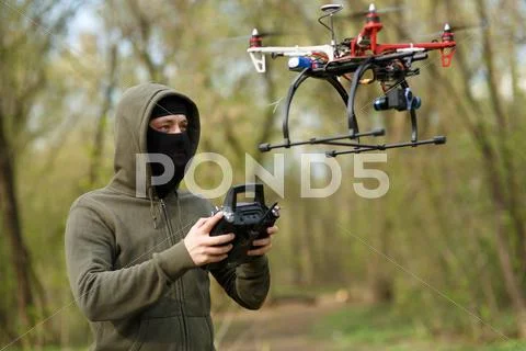 Man In Mask Operating A Drone With Remote Control - Stock Image ...