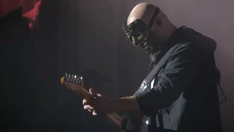 A man in a mask plays an electric bass g... | Stock Video | Pond5