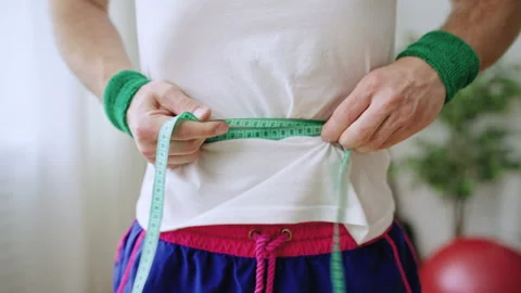Man measuring waist with a tape, trying ... | Stock Video | Pond5