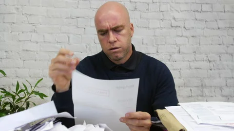 A man opening a bill envelope at a desk ... | Stock Video | Pond5