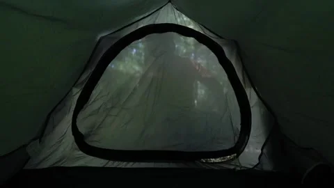 Man opens a tent zip and enters inside. ... | Stock Video | Pond5