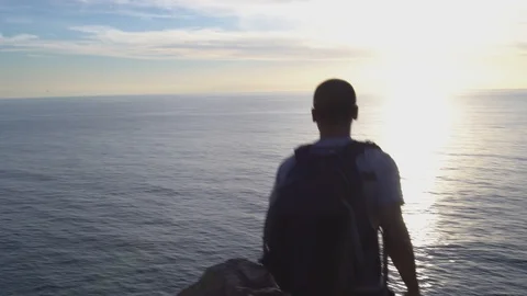 man overlooking ocean from a cliff raisi... | Stock Video | Pond5