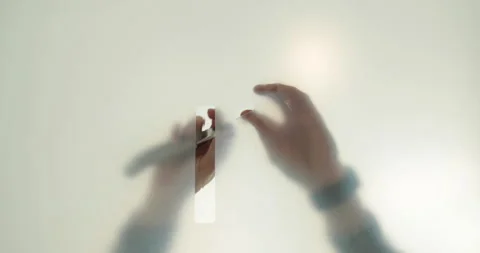 A man pastes a frosted coating on a glas... | Stock Video | Pond5