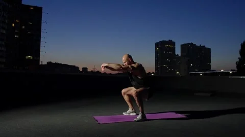 A man performs a static squat exercise o... | Stock Video | Pond5