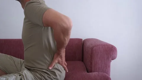 Man with pinched back nerve indoor. | Stock Video | Pond5