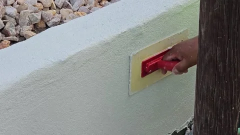 Man plastering retaining wall with stucc... | Stock Video | Pond5