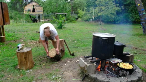 Man with ponytail using axe to try split... | Stock Video | Pond5