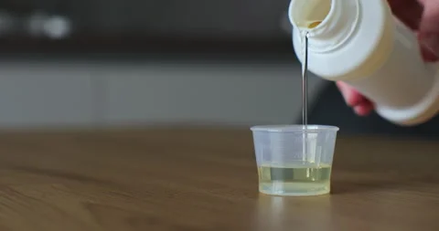 Man pours medical syrup into measuring c... | Stock Video | Pond5