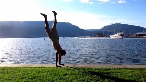 man practicing handstand by the lake, in... | Stock Video | Pond5
