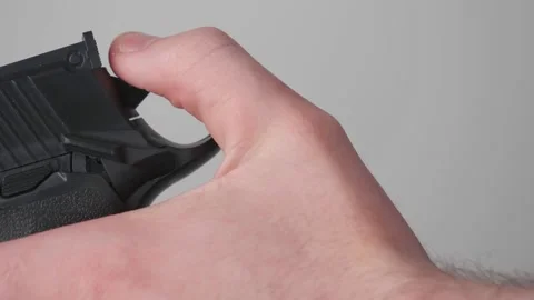 Man pulls the trigger of a pistol back, ... | Stock Video | Pond5