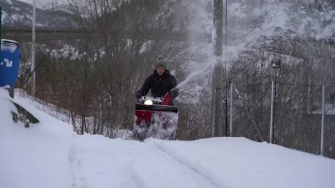 Man pushing snowblower clears driveway a... | Stock Video | Pond5