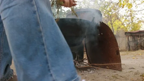 Man Puts Branches In The Fire While Cook... | Stock Video | Pond5