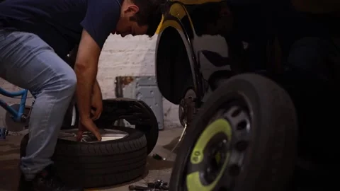 Man Is putting up donut tire inside an a... | Stock Video | Pond5