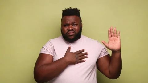 Man raising one hand and holding on ches... | Stock Video | Pond5