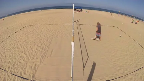 A man rakes a beach volleyball court. | Stock Video | Pond5