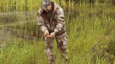 Man releasing a trout fish in lake | Stock Video | Pond5