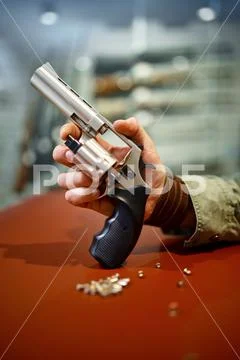 Man reload revolver at the counter in gun store ~ Premium Photo #158059399