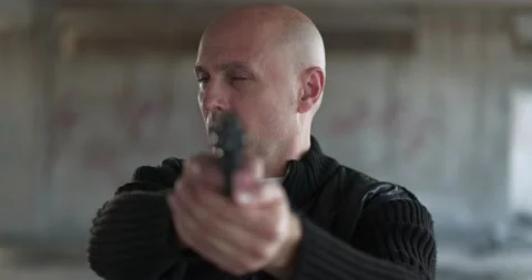 Man with revolver looks at the camera, ... | Stock Video | Pond5