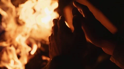Man rubbing hands in front of burning fi... | Stock Video | Pond5