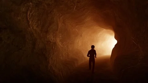 man running in the cave tunnel towards t... | Stock Video | Pond5