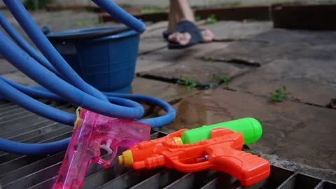 man running to pick up water gun | Stock Video | Pond5