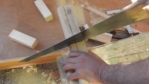 Man sawing a wooden block with a hand sa... | Stock Video | Pond5