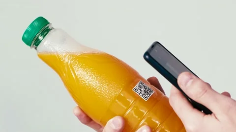 A man scanning a QR code on juice bottle... | Stock Video | Pond5