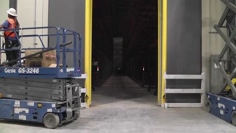 Man On Scissor-Lift Rides Past Automatic... | Stock Video | Pond5