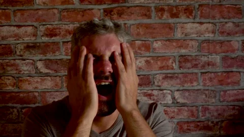 A man screaming at a brick wall 4K | Stock Video | Pond5