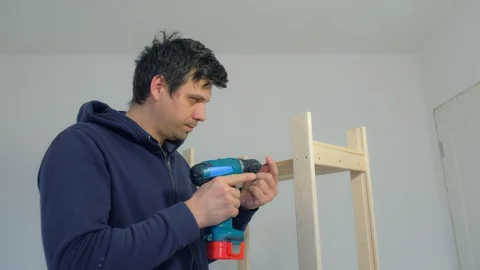 Man screws boards using electric screwdr... | Stock Video | Pond5