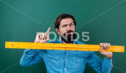 Photograph: Man serious with size measured on ruler math tool, inspired ...