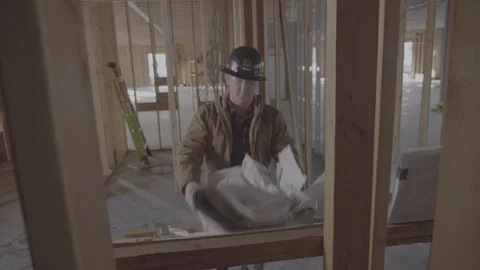 A man sets construction plans onto a des... | Stock Video | Pond5