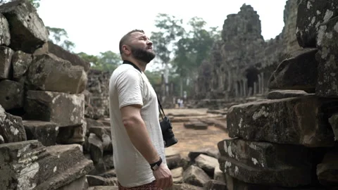 Man sightseeing ancient Angkor Wat templ... | Stock Video | Pond5