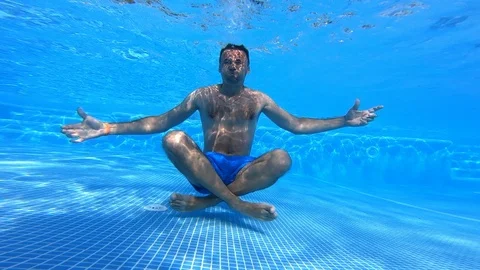 Man sits on the bottom of swimming pool.... | Stock Video | Pond5
