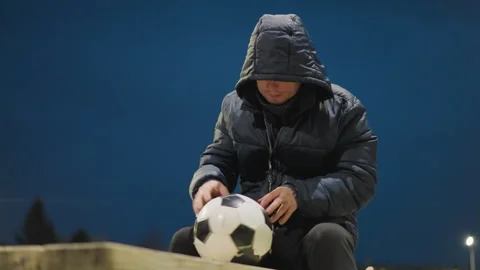 Man Sitting on Bench Rotating Soccer Bal... | Stock Video | Pond5