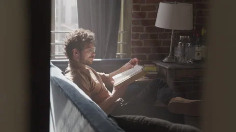 Man Sitting Down Reading a Book | Stock Video | Pond5