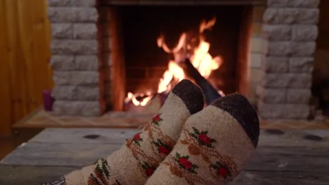 man is sitting by the fireplace and wigg... | Stock Video | Pond5